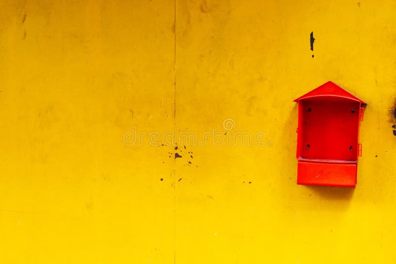Damaged Red Post Box Set Against a Striking Yellow Background Stock ...