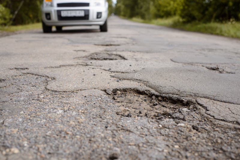 Damaged Road and Approaching Car on the Background Stock Photo - Image ...