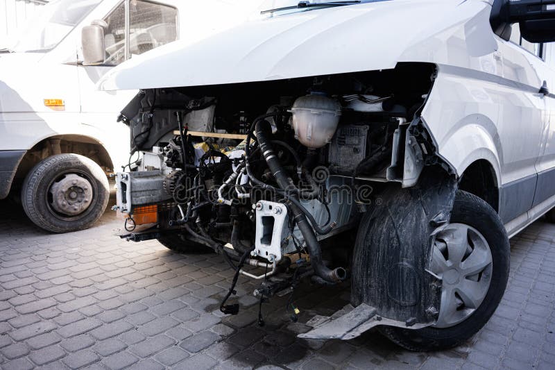 Damaged White Van Undergoing Repairs with Exposed Engine Components ...