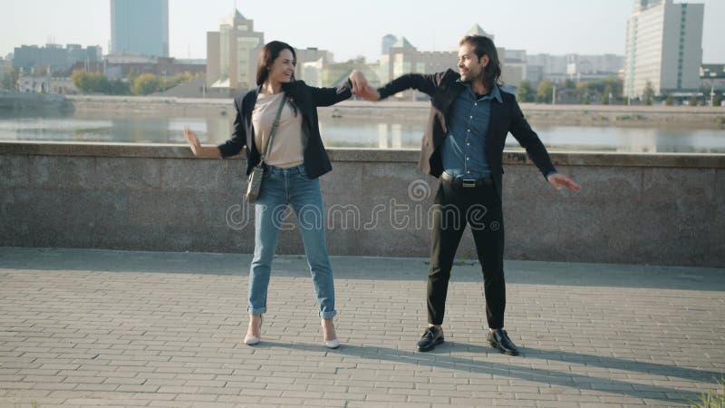 Dance Loop of Cheerful Young Couple Holding Hands and Making Wave ...