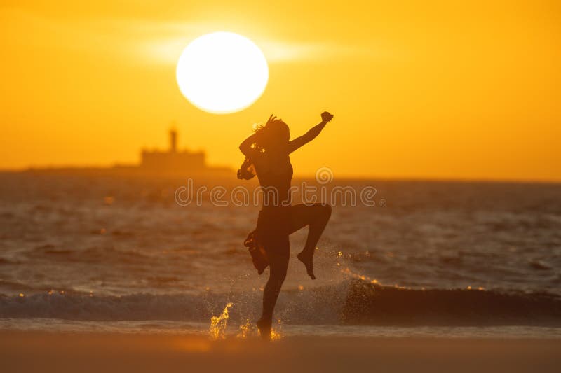 Dancer Performing on Beach at Sunset with Lighthouse in Background Stock Photo - Image of ...