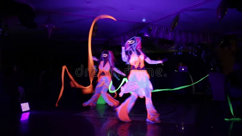 Dancers in Glowing Neon Costumes Perform in a Dark Room Stock Video ...