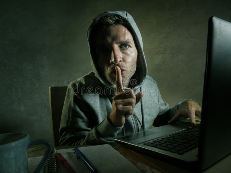 Dangerous Looking Young Hacker Man in Hoodie Typing on Laptop Computer ...