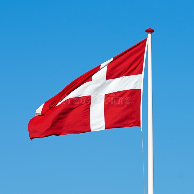 The Danish Flag. the Danish Flag Blowing Against a Blue Background ...