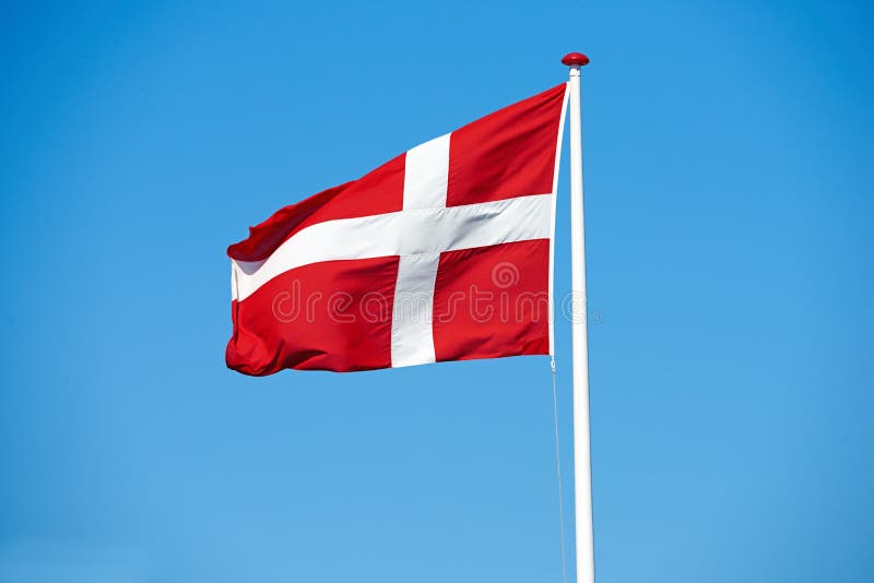The Danish Flag. the Danish Flag Blowing Against a Blue Background ...
