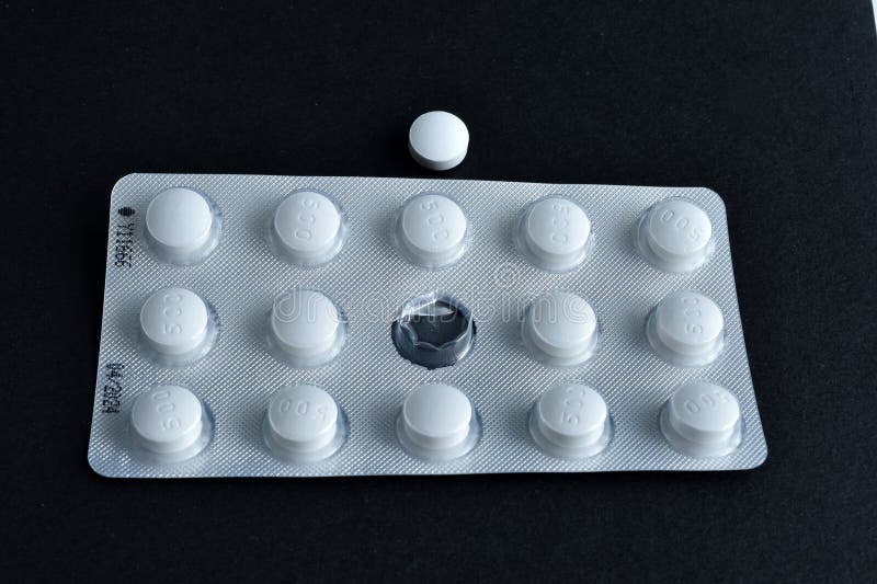 A Package of Pills, in Four Rows, and a Pill Lie on a Dark Background ...