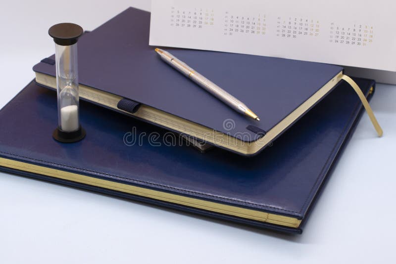 Dark Blue Leather Notebooks,hourglass and a Pen. Preparing for a ...