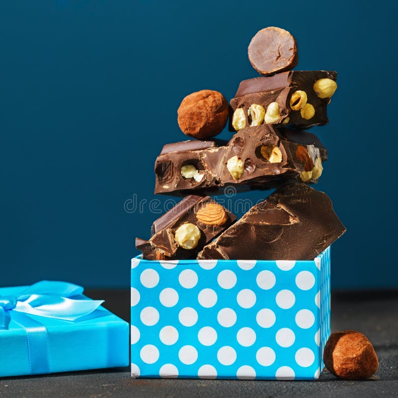 Dark Chocolate Stack and Gift Box on Blue Background Stock Photo ...