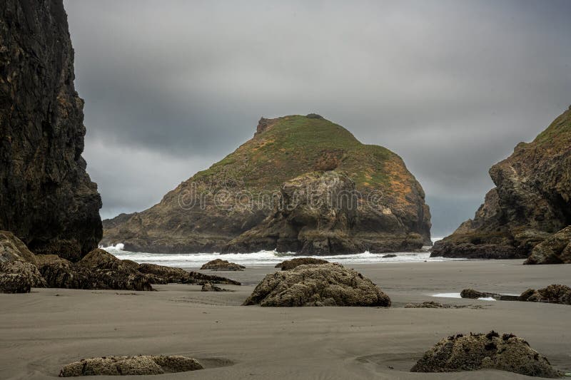 Dark Clouds Hang Over Sea Stack at Low Tide on Meyers Beach Stock Photo ...
