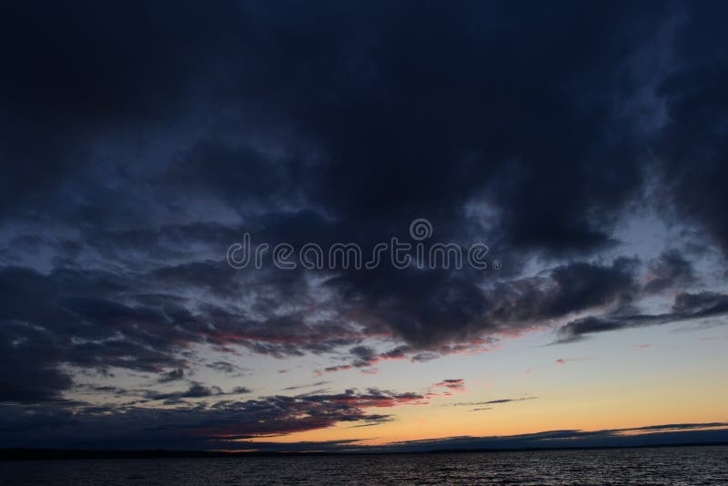 Dark Clouds of the Twilight Sky Over the Water Surface of the Lake ...