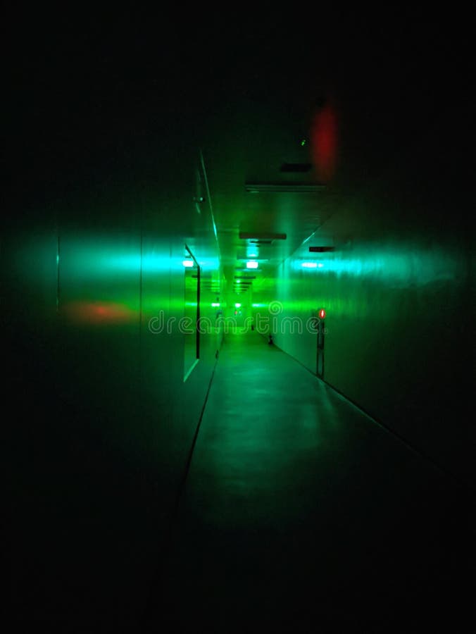 A Dark Corridor with Dark Green Blue Exit Sign Light in a Factory Stock ...