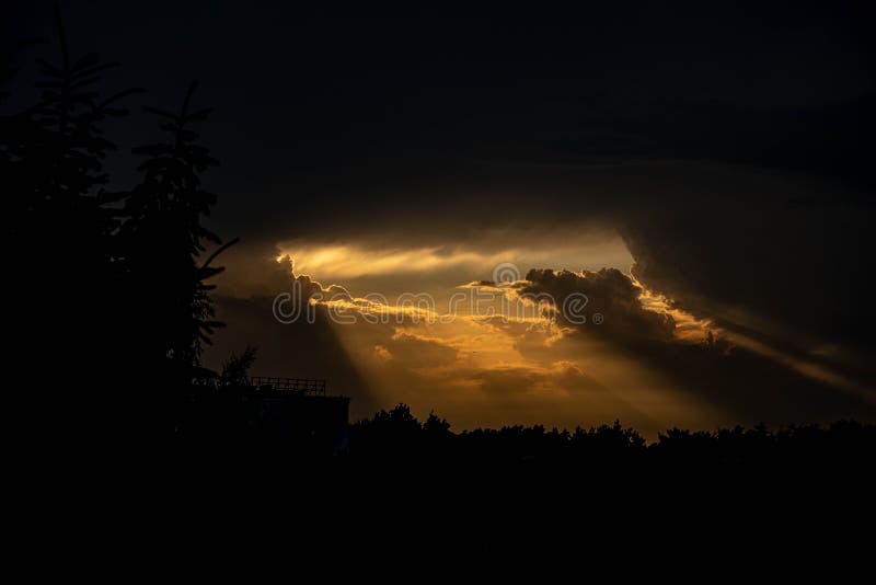 Dark Dense Sky and Rays of Warm Orange Light Getting Out of the Clouds ...