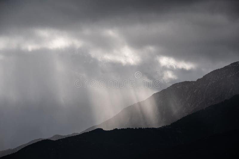 Dark Dramatic Sky with Light Rays and Mountains Silhouettes Stock Photo ...
