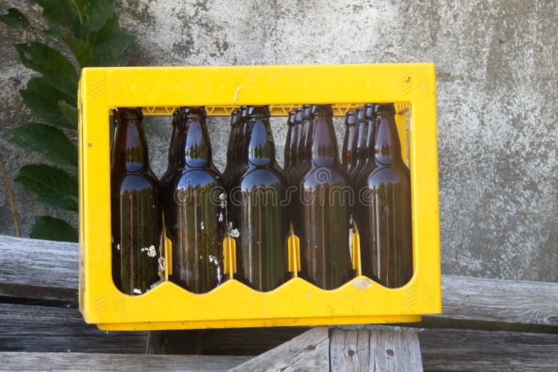 Dark Empty Beer Bootle in Yellow Case Box on Wood Pieces at Outside in ...