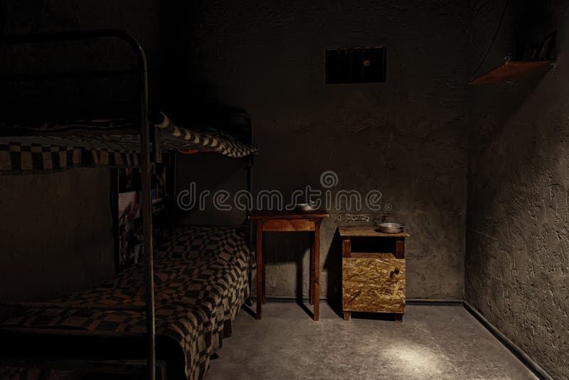A Dark Empty Prison Cell with Iron Bunk Bed and Bedside Table Stock ...