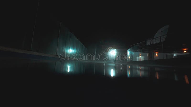 A Dark, Empty Street with a Pool of Water Reflecting the Lights. Scene ...