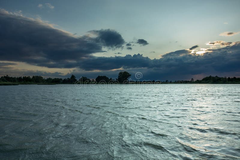 Dark Evening Clouds at the Lake with Small Waves Stock Photo - Image of ...