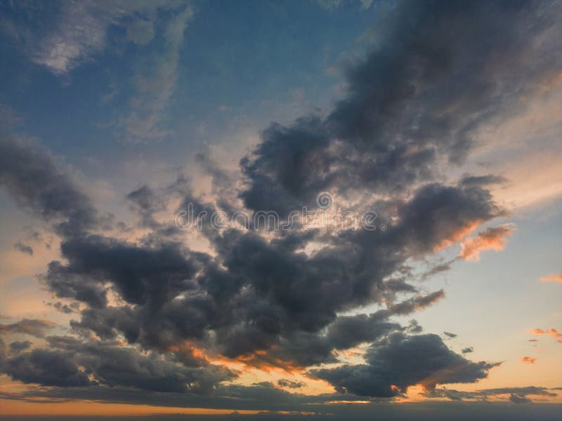 Dark, Foreboding Clouds Loom Over an Orange Horizon, Where the Sunset ...