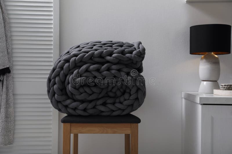 Dark Grey Chunky Knit Blanket Rolled on Wooden Stool in Room Stock ...