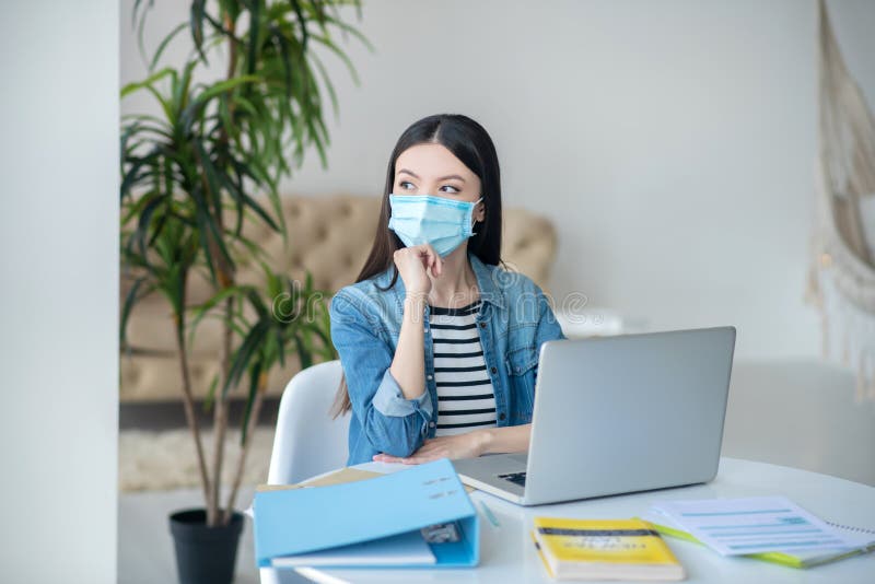 Dark-haired Female Sitting at Her Desk in Front of Laptop, Wearing ...