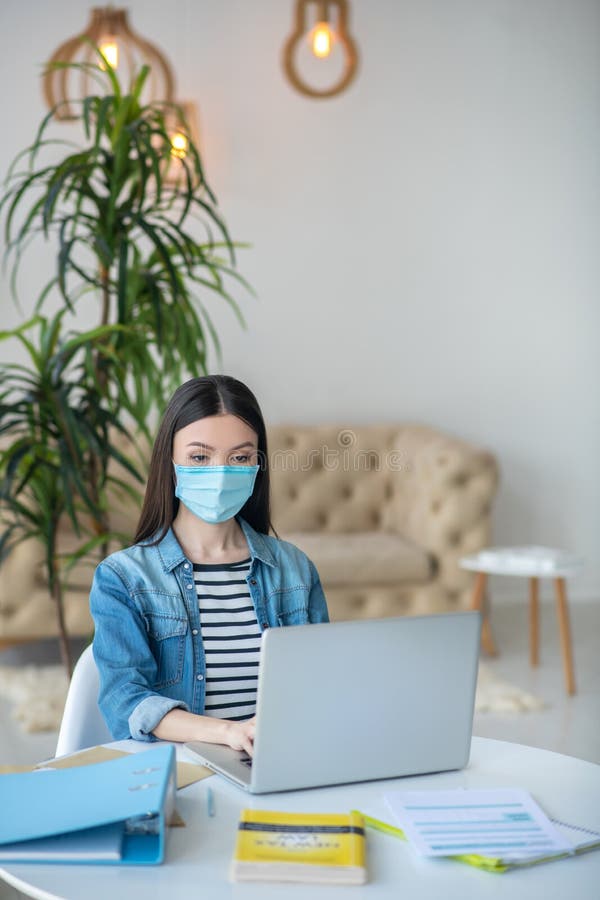 Dark-haired Female Sitting at Her Desk, Typing on Laptop, Wearing ...