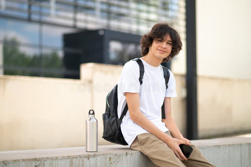 Dark-haired Teenager Sitting on the Blocks and Resting after Classes ...