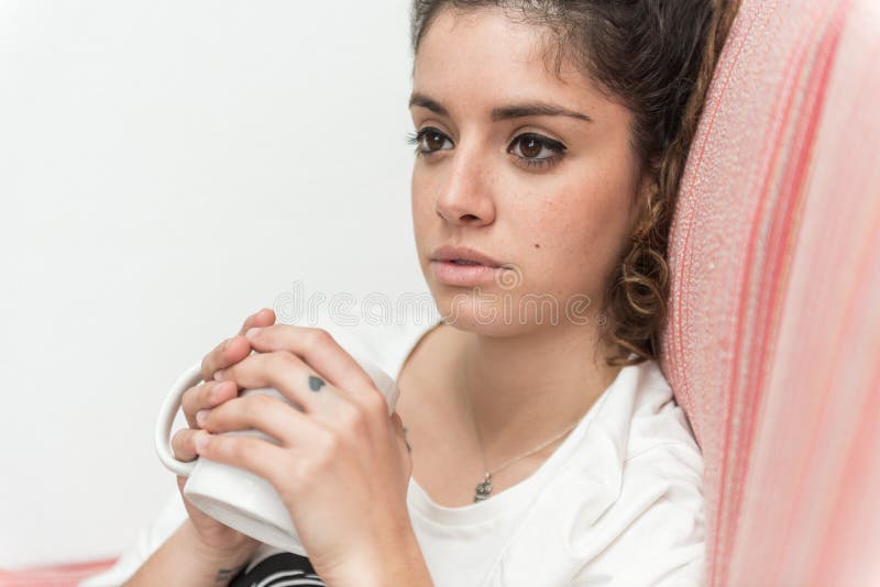 Dark Haired Thoughtful Young Woman Takes A Cup Sitting On The Couch