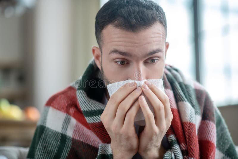 Dark-haired Young Sick Man Holding a Napkin and Sneezing Stock Photo ...