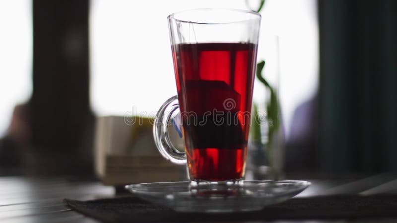 Glass Cup of Tea with Tea-bag Inside Placed on Table at Dark Restaurant ...