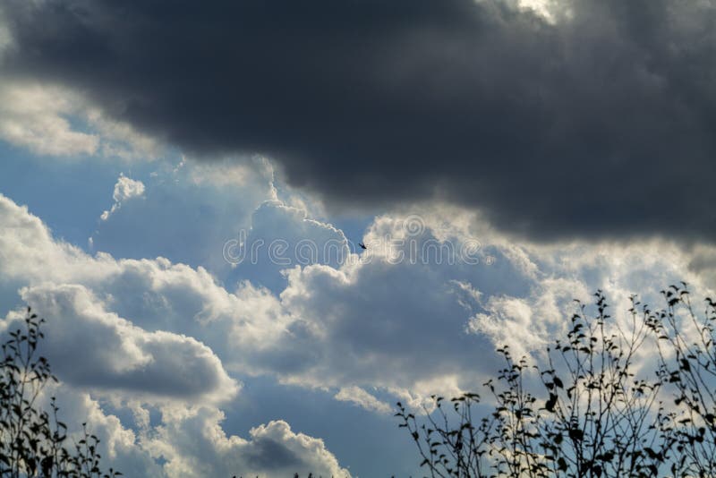 A Dark Helicopter Flying Overhead with a Cloudy Blue Sky in the ...