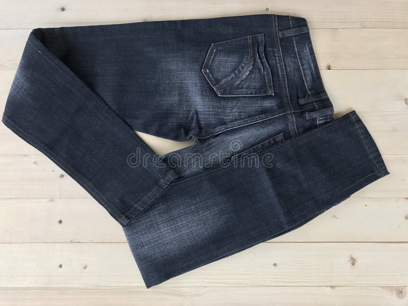 Folded jeans on wood floor stock photo. Image of detail - 97712104