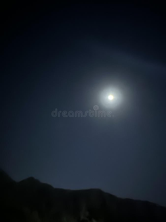 A Dark Night in the Mountains with a Bright Moon Setting Over Some ...