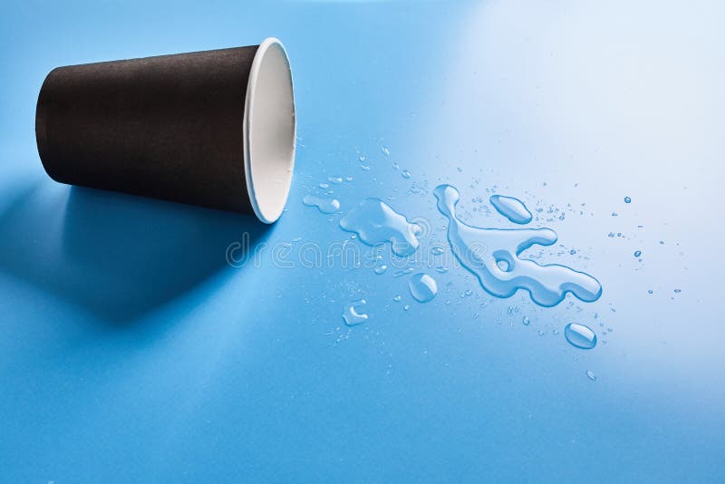 Dark Paper Cup with Abstract Drops of Spilled Water on Blue Background ...