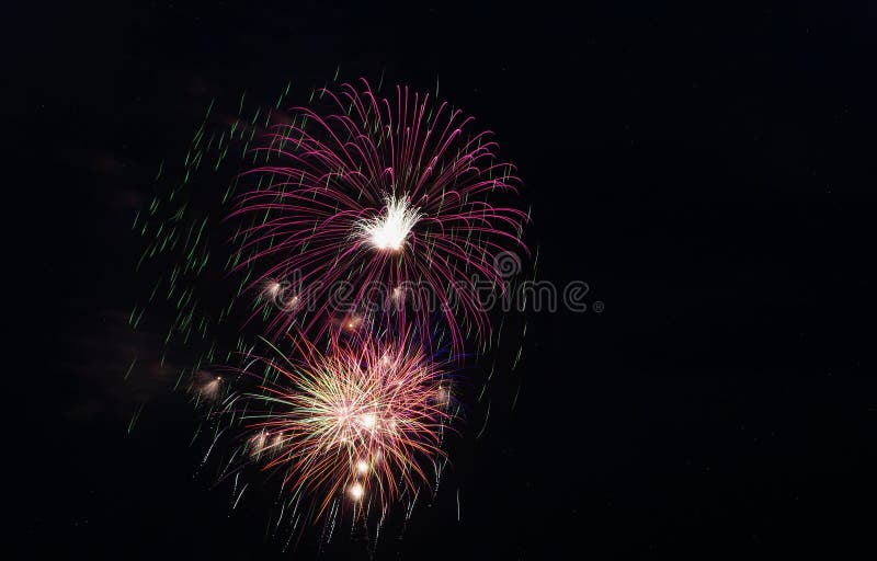 Pink Comet Firework with Green Highlights and White Center Against a ...