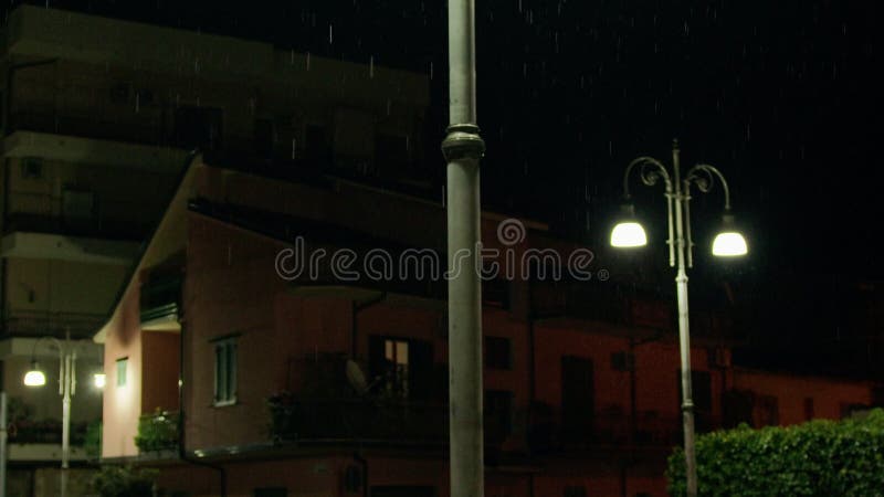 A Rainy Night Scene of a City Street with Wet Pavement and Streetlights ...