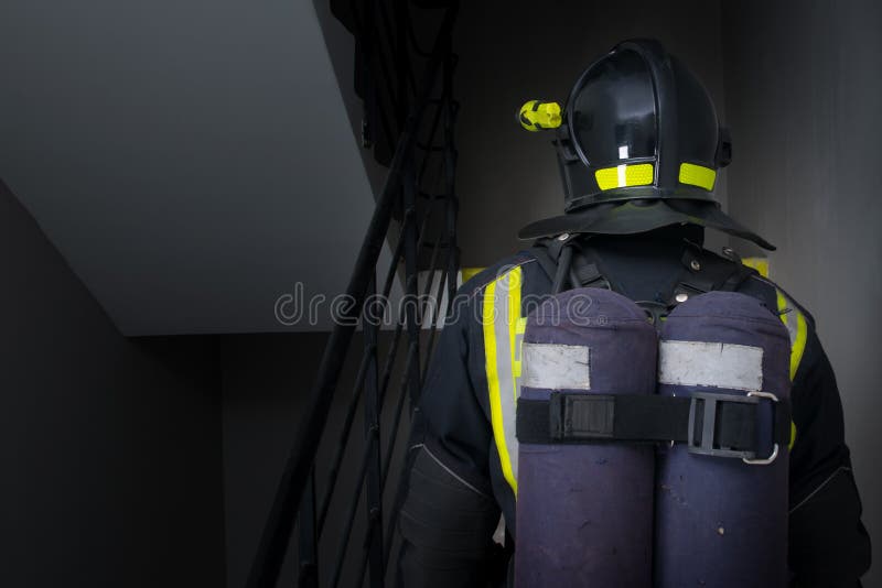 In a Dark Room, Close-up of the Back of a Firefighter in Protective ...