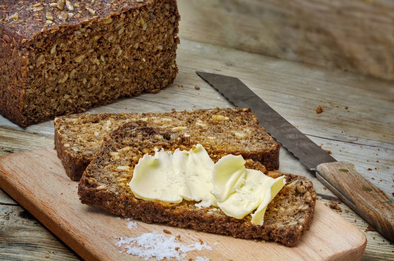 Dark Rye Bread with Seeds, Butter and Salt on Rustic Wood Stock Photo ...