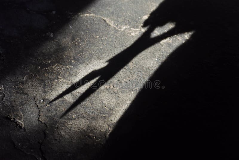 Dark Shadow of a Hand Holding Scissors on the Concrete Surface Stock ...