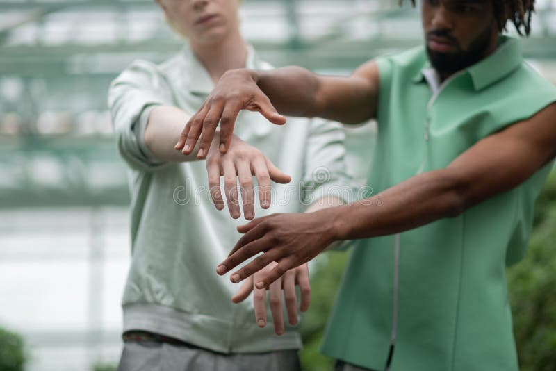 Dark-skinned Man and Blonde Man Putting Out Hands Stock Image - Image ...