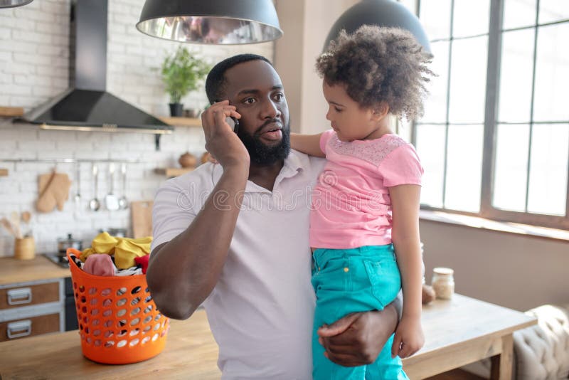 Dark-skinned Tall Father Holding His Kid and Talking on the Phone Stock ...