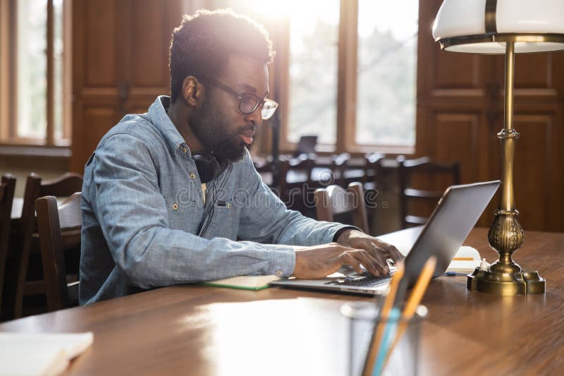Dark-skinned Young Man Sitting at the Laptop in the Library Stock Photo ...