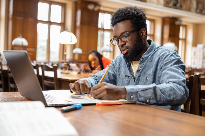 Dark-skinned Young Man Working Online in the Library Stock Image ...