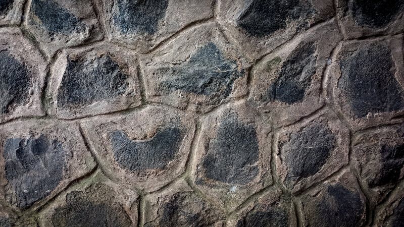 A Dark Stone Wall with Light Mortar, Showing a Rough, Natural Texture ...