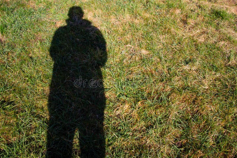 Dark Tall Shadow of a Man with Coat in the Grass with Copy Space Stock ...