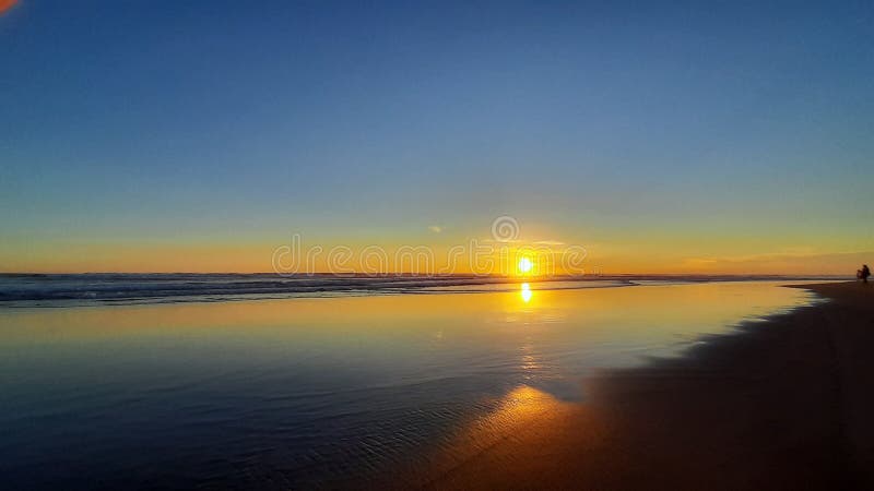 Dark Yellow Sun Light while Sunset at a Sand Beach with Smooth Blue Sky ...