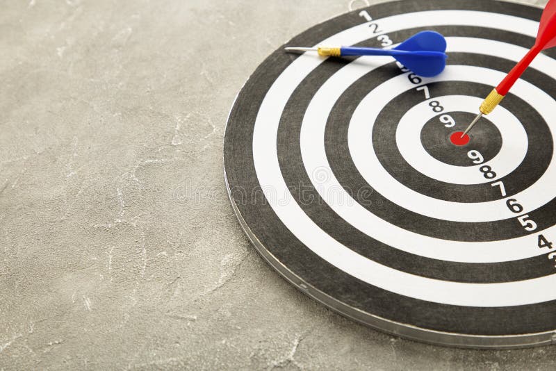 Dart Board with Blue and Red Darts on Green Background Stock Photo ...