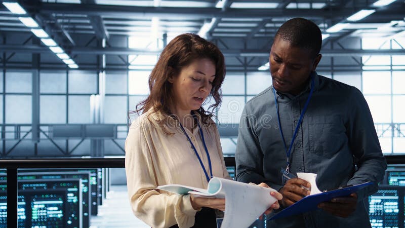 Data Center Engineer Greeting Colleague, Examining System Diagnostics ...