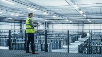 Data Center Engineer in High Visibility Vest Using Laptop Computer ...