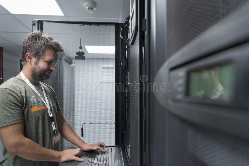 Data Center Engineer Usaing Keyboard on a Supercomputer Server Room ...