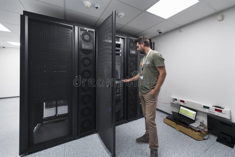 Data Center Engineer Usaing Keyboard on a Supercomputer Server Room ...